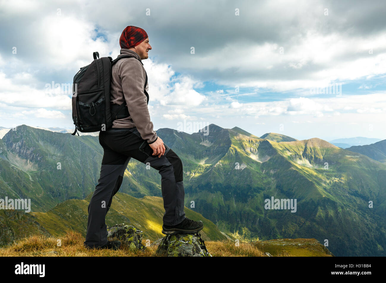 Man hiking with backpack into the mountains Stock Photo - Alamy