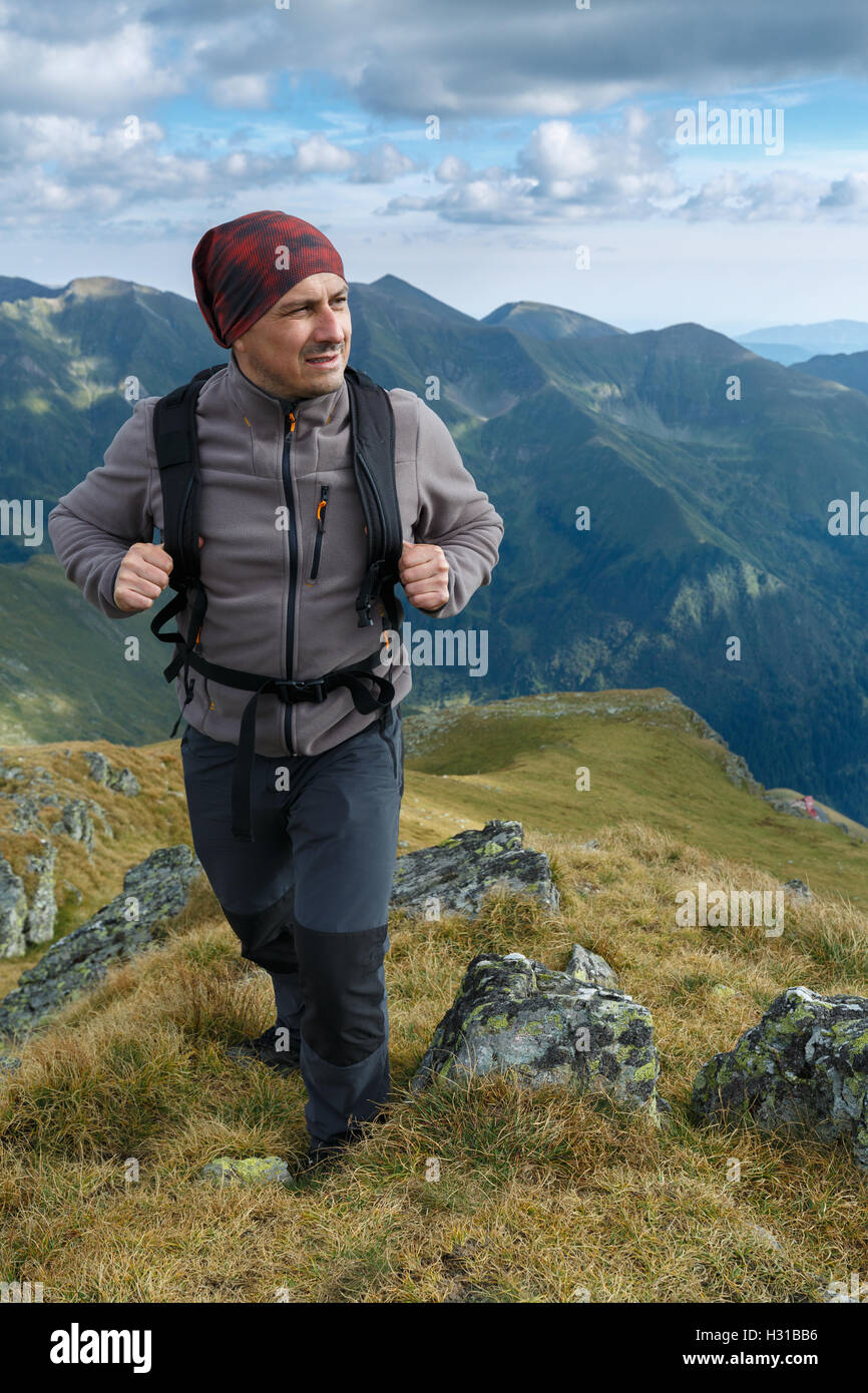 Man hiking with backpack into the mountains Stock Photo - Alamy