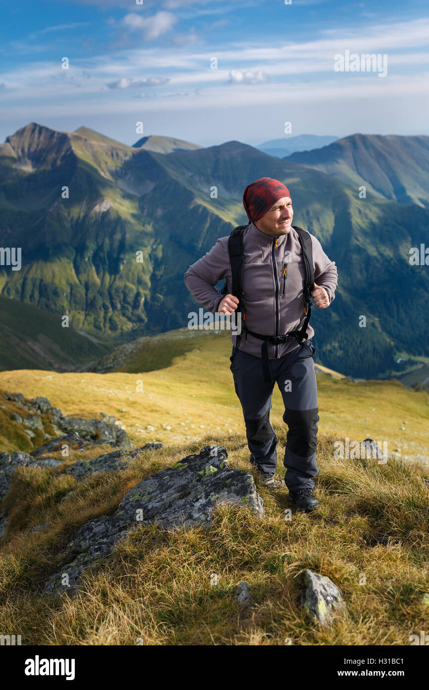 Man hiking with backpack into the mountains Stock Photo - Alamy