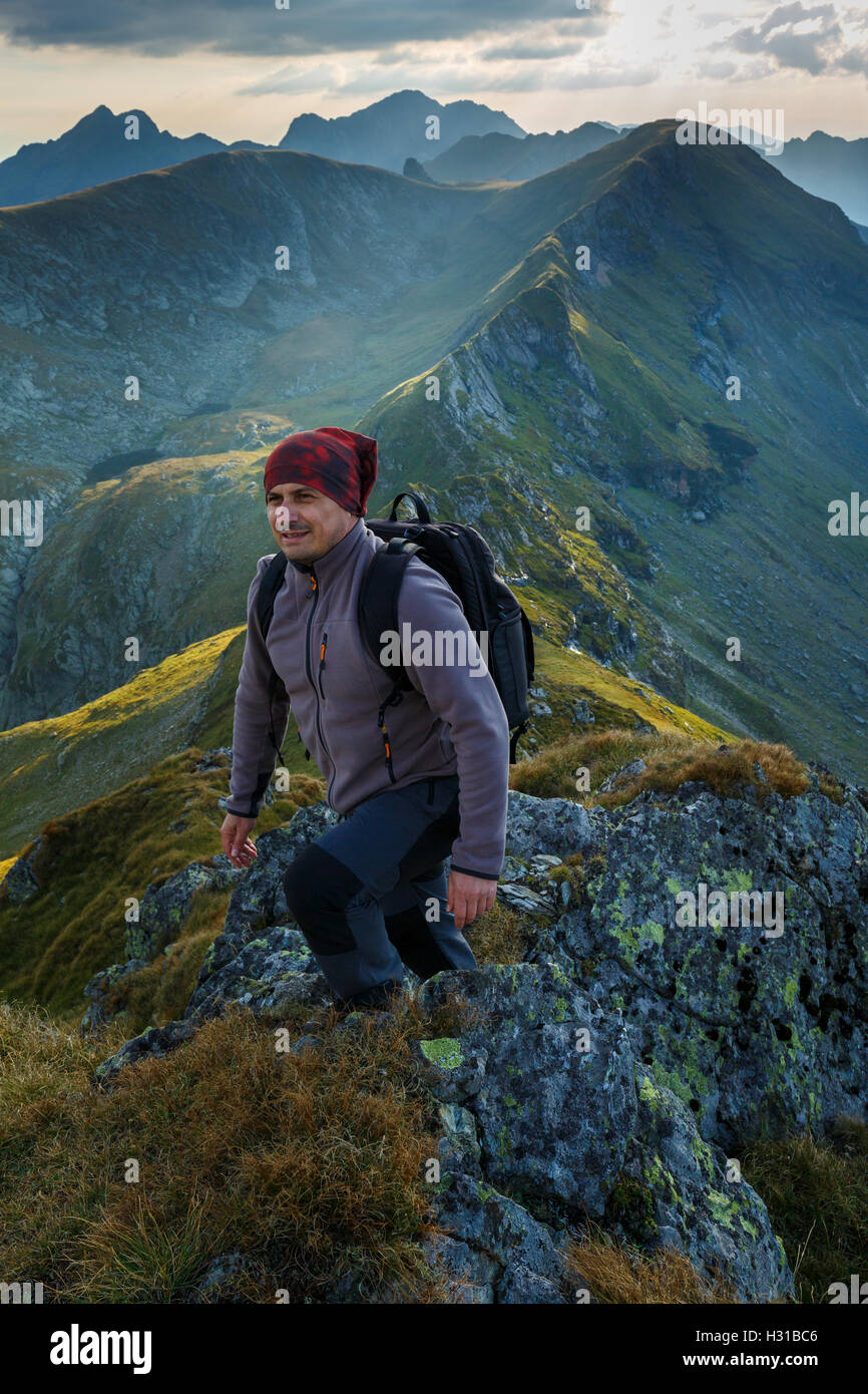 Man hiking with backpack into the mountains Stock Photo - Alamy