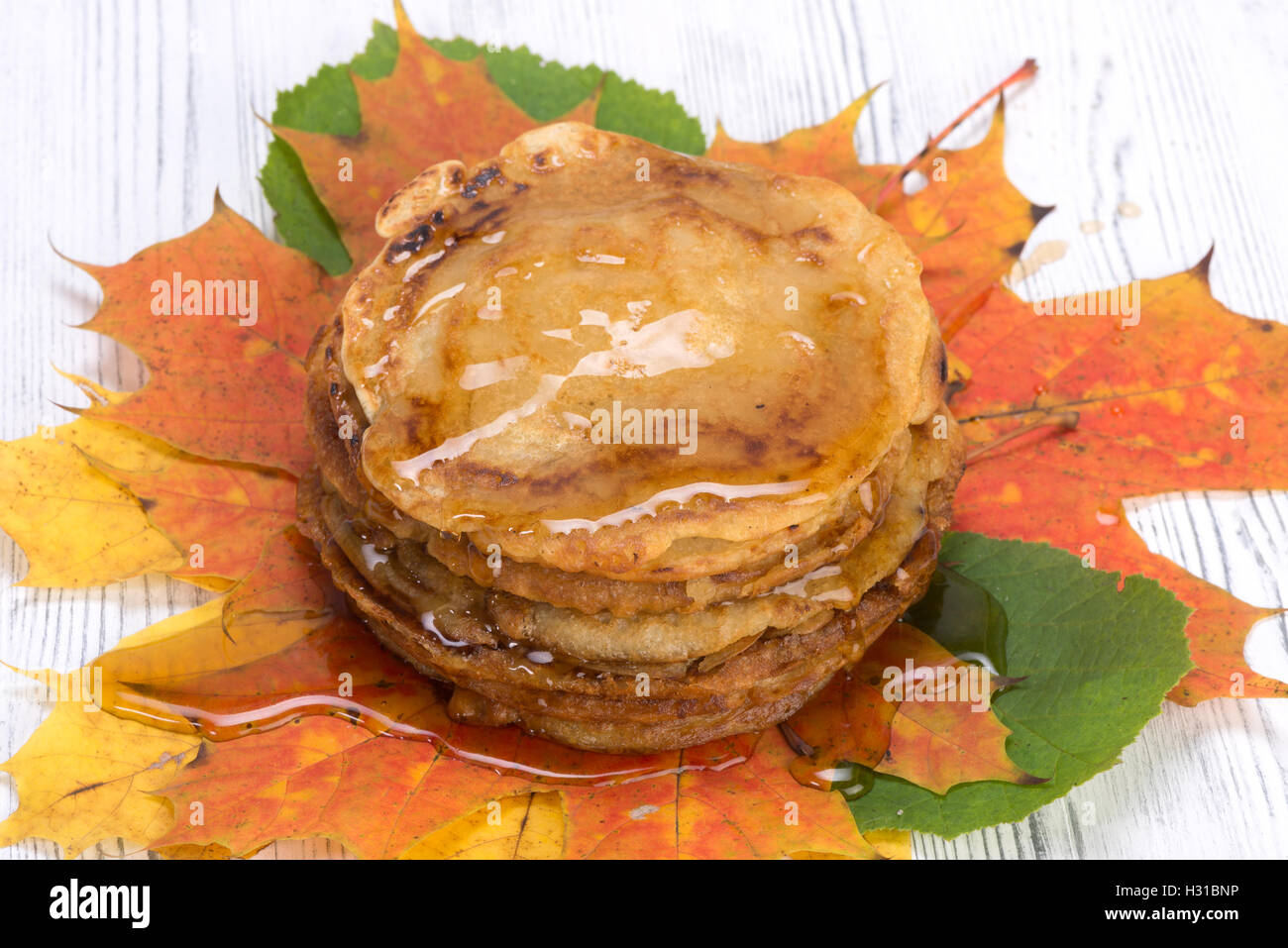 pancakes topped with maple syrup lie on autumn maple leaves Stock Photo ...