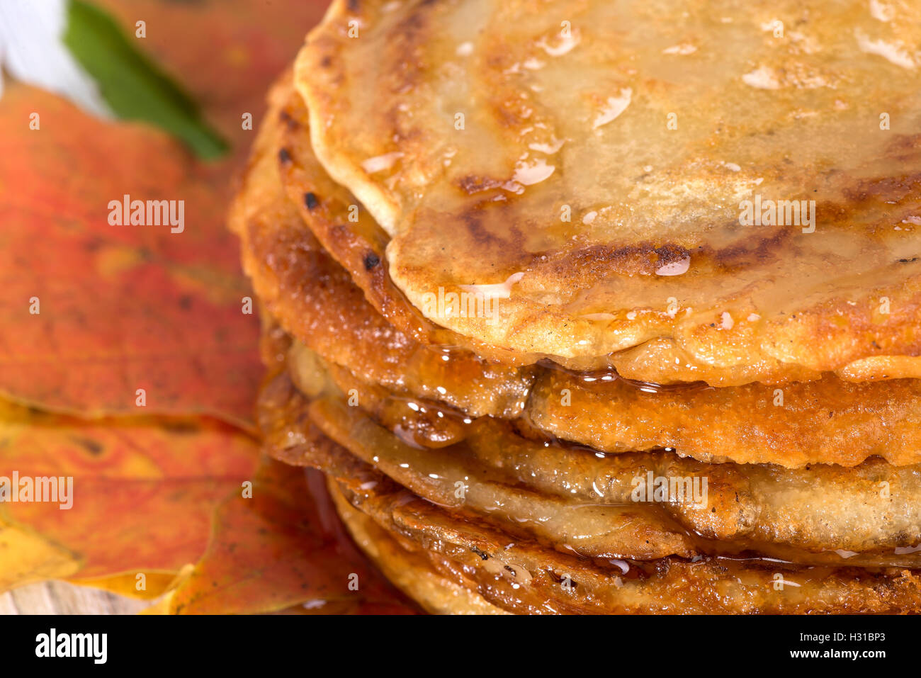 pancakes topped with maple syrup lie on autumn maple leaves Stock Photo ...