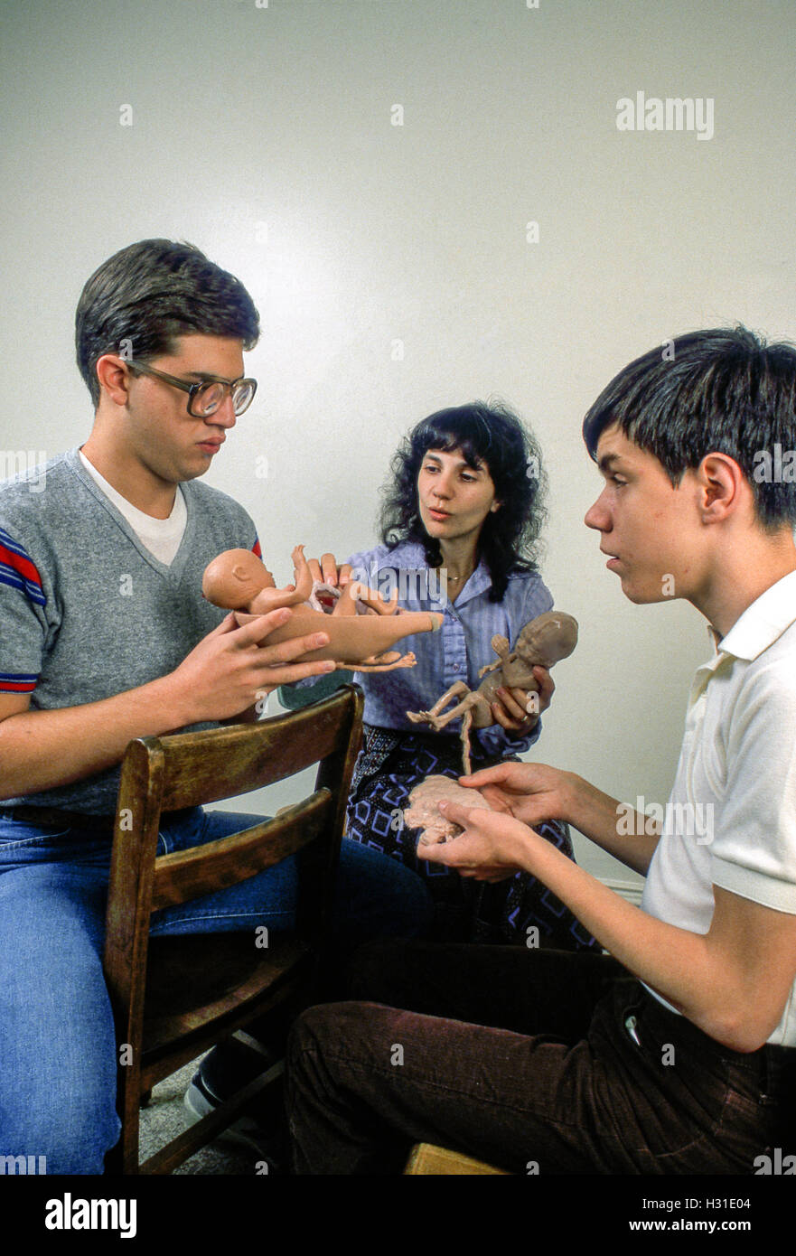 Blind teenage boys are familiarized with a newborn baby by touching a ...