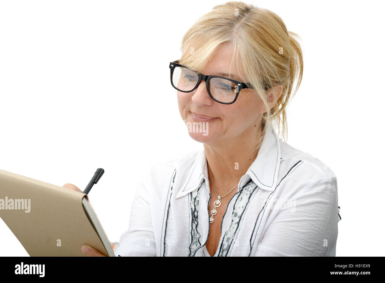 a mature woman writing on a notebook Stock Photo - Alamy