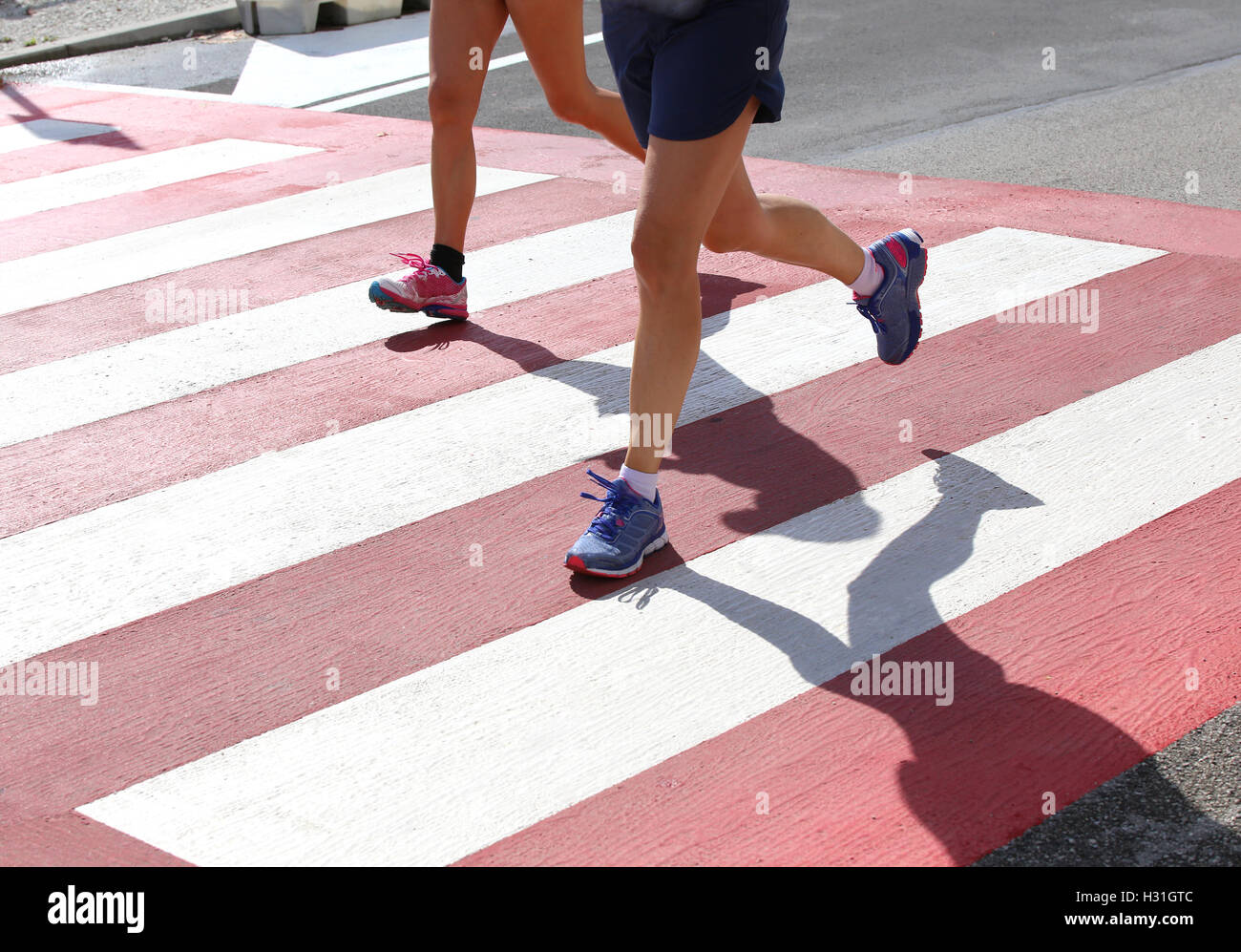 runners during a marathon race in the city on a pedestrian crossing ...