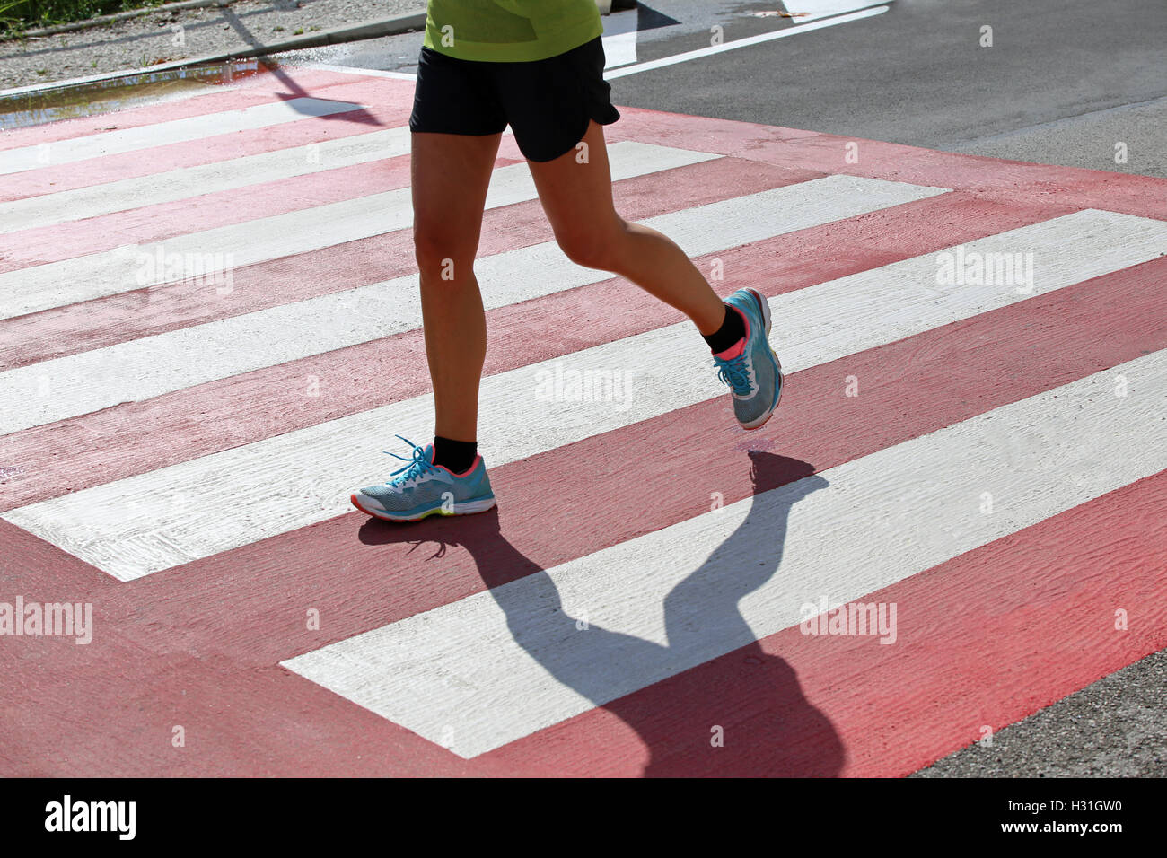 athlete during the race on the crosswalk of the city street Stock Photo ...