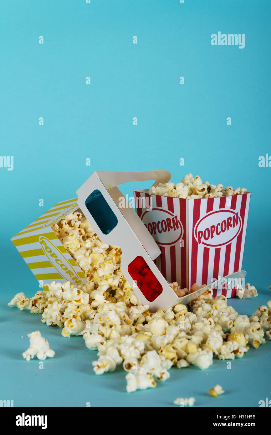 Bucket of popcorn against a blue background Stock Photo - Alamy