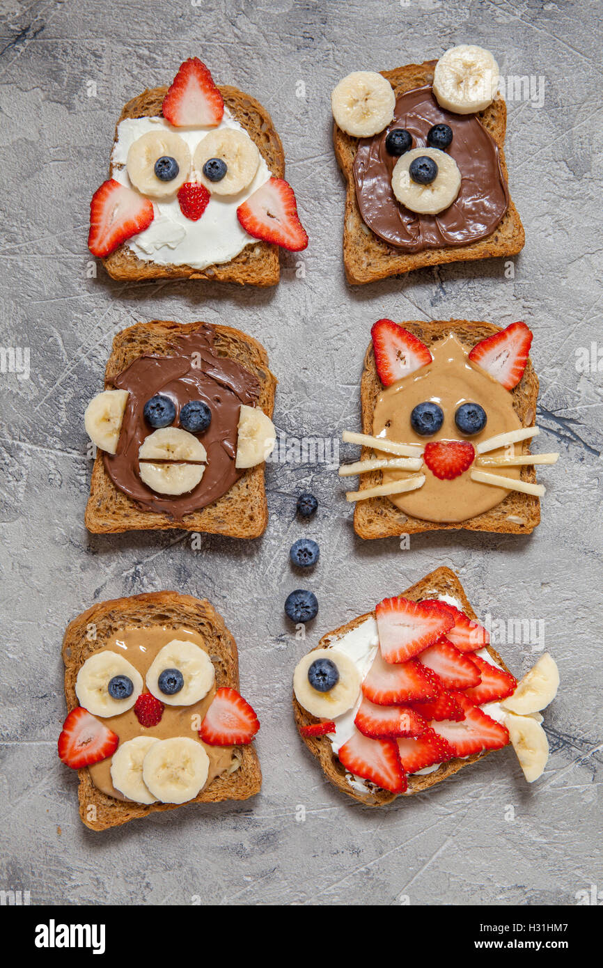 Funny animal faces toasts with spreads, banana, strawberry and ...