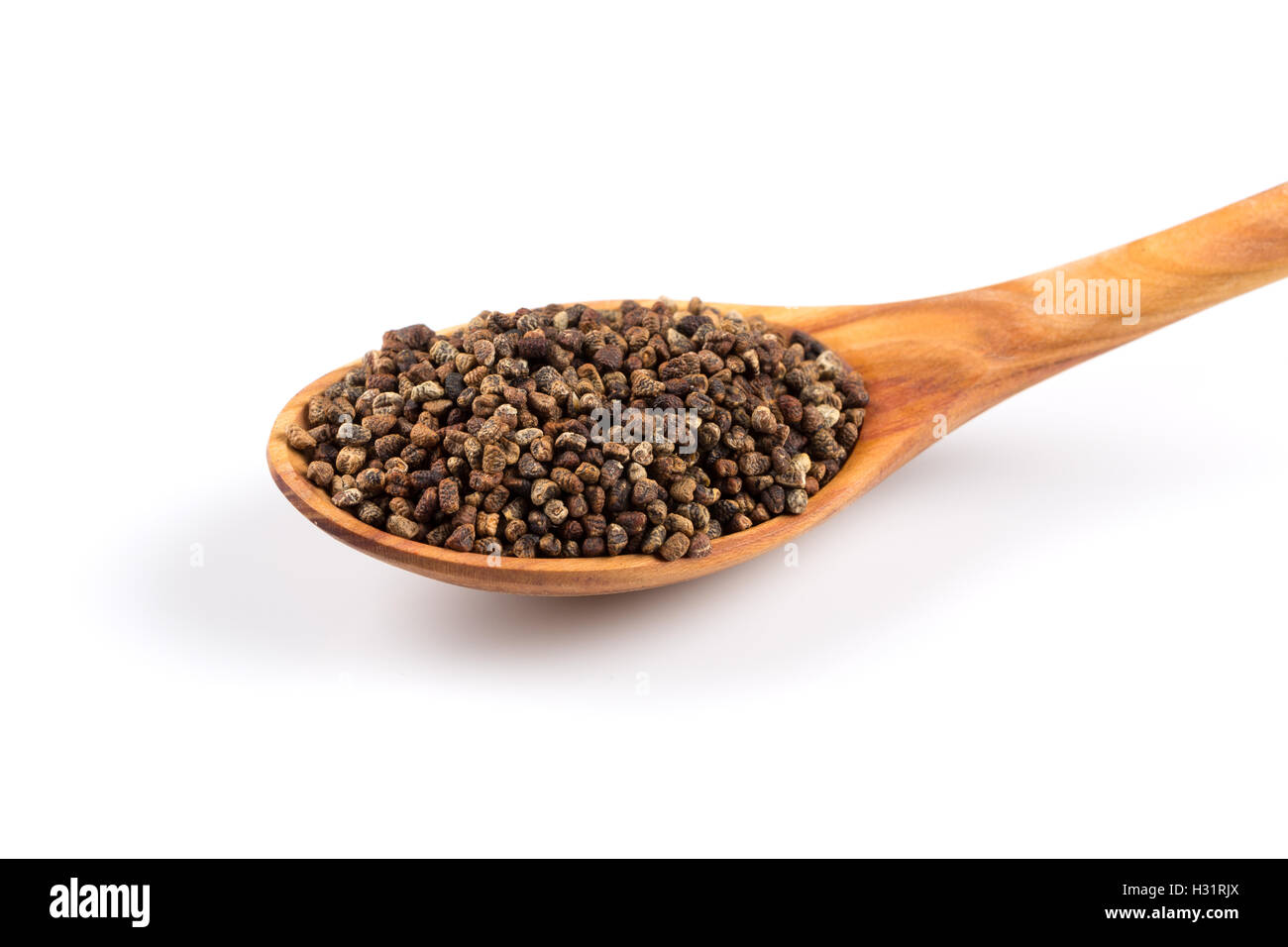 Decorticated cardamom seeds in a wooden spoon on white background Stock ...