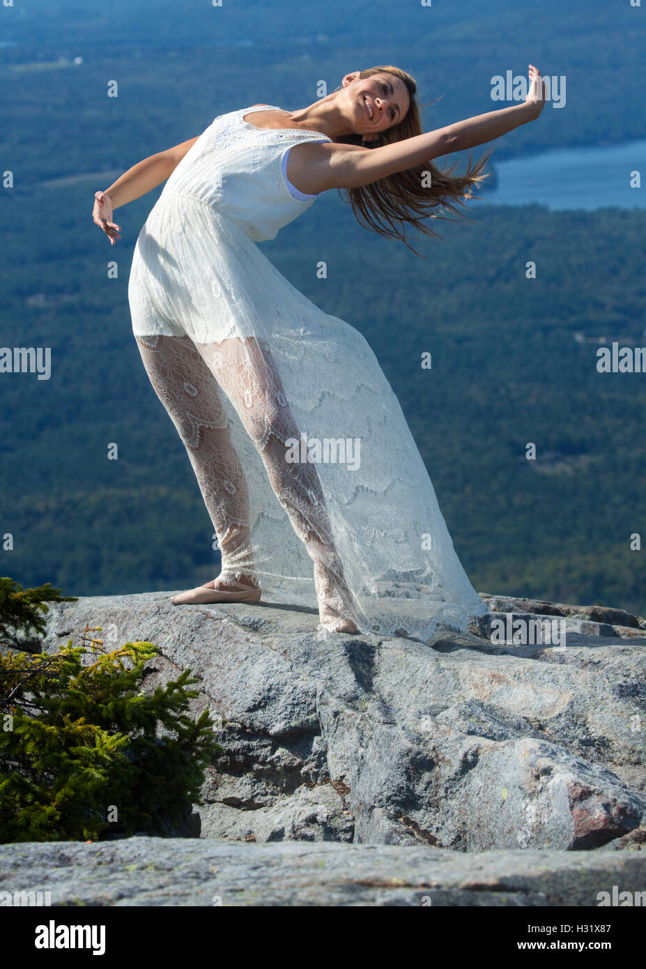 Female dancer in white dress dancing in the wind on summit of Mt ...