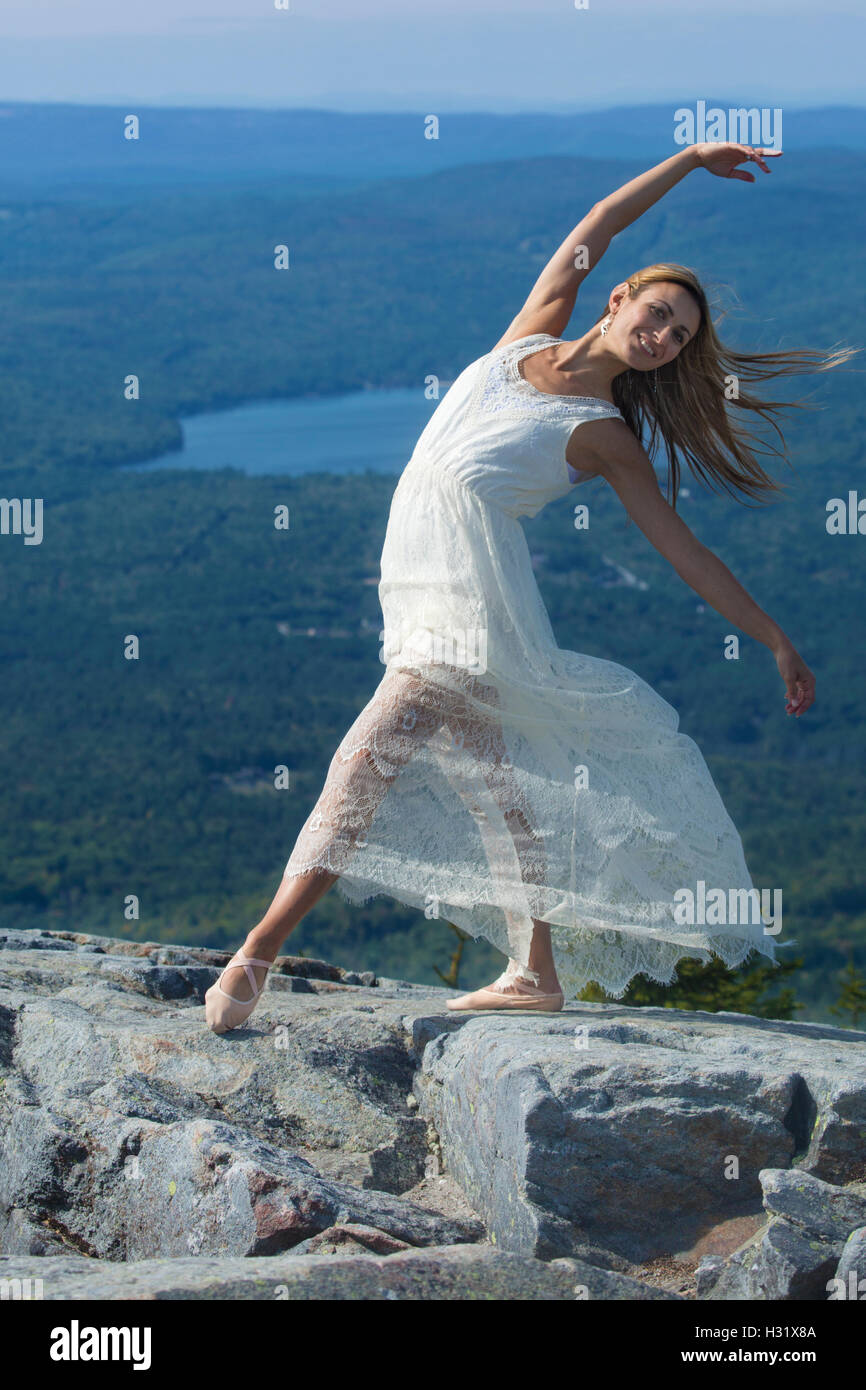 Female dancer in white dress dancing in the wind on summit of Mt ...