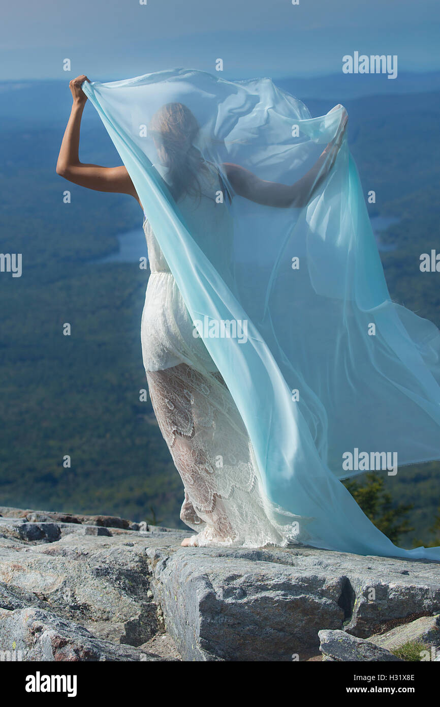 Female dancer in white dress dancing with green fabric in the wind on ...
