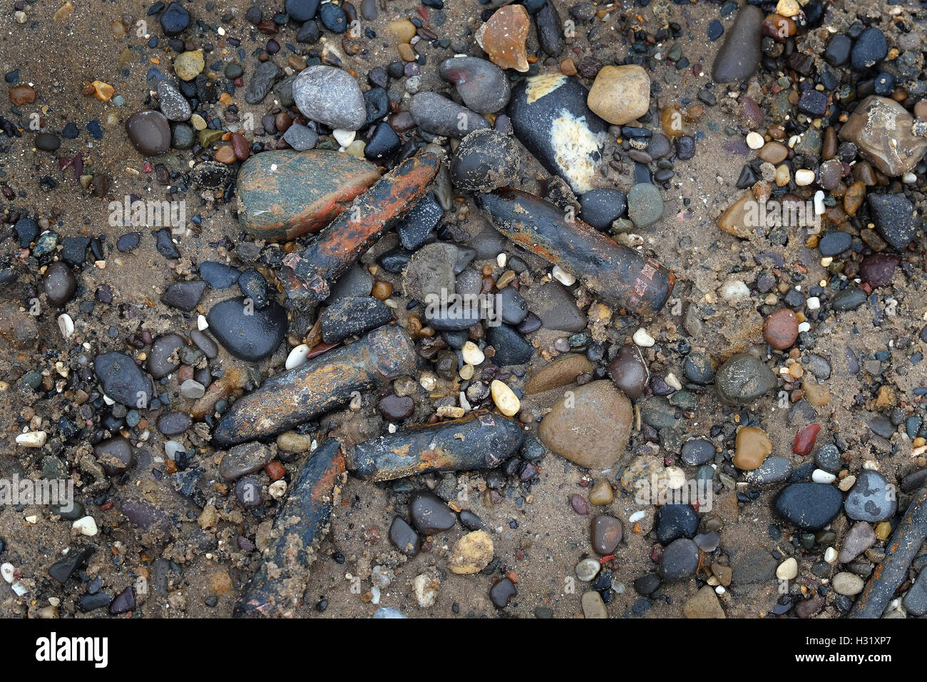 Spent world war two twenty millimeter cannon shells in wet sand on a ...