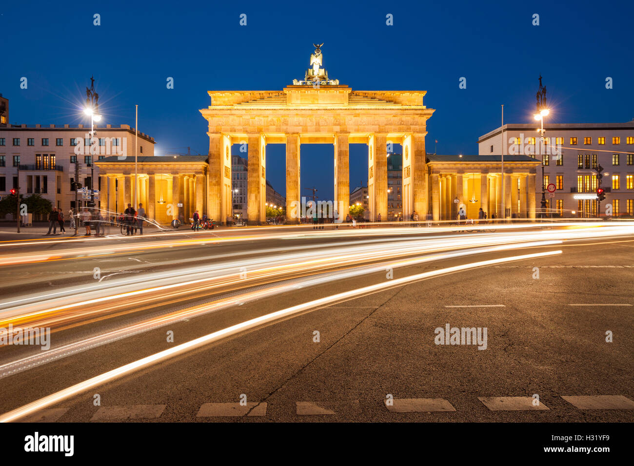 Berlin's Brandenburg Gate at twilight with speeding traffic light ...