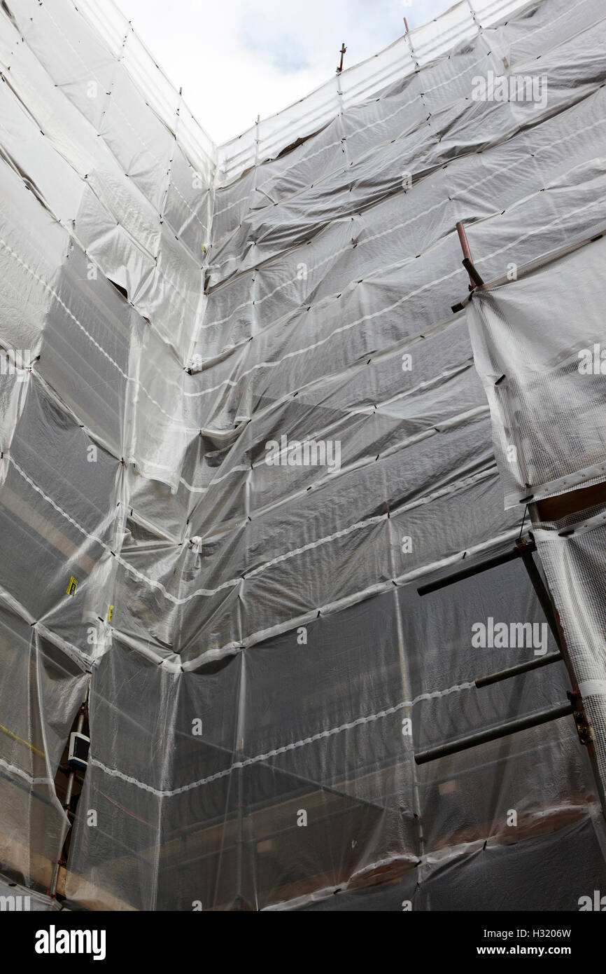 Building covered in scaffolding & plastic sheets Stock Photo - Alamy
