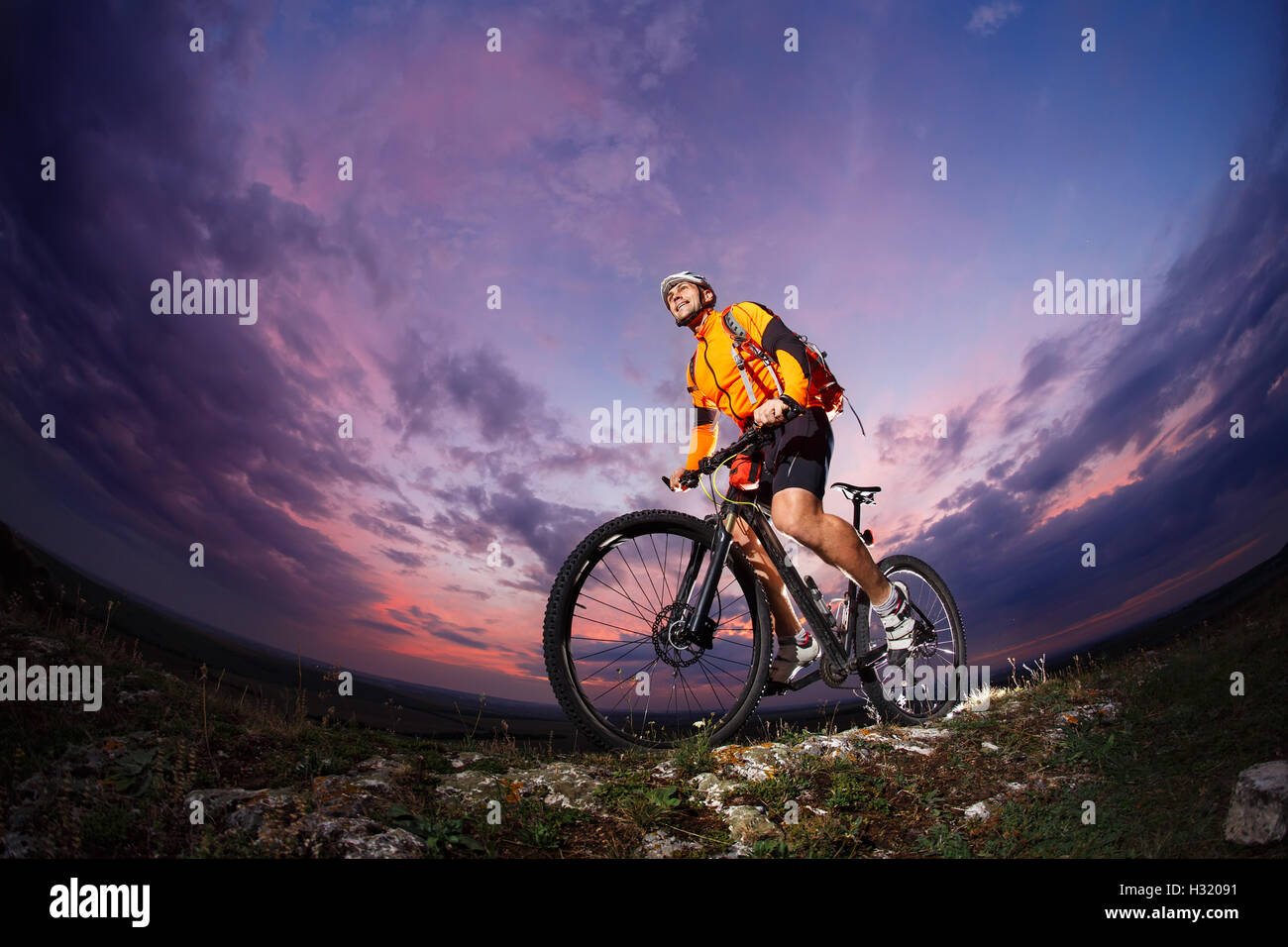 low angle view of cyclist standing with mountain bike on trail at ...