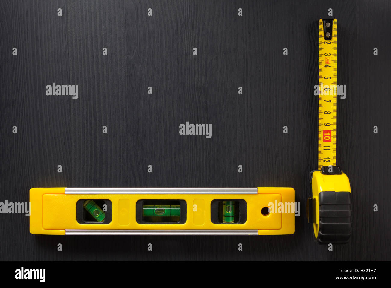 tape measure and level on wooden texture Stock Photo - Alamy