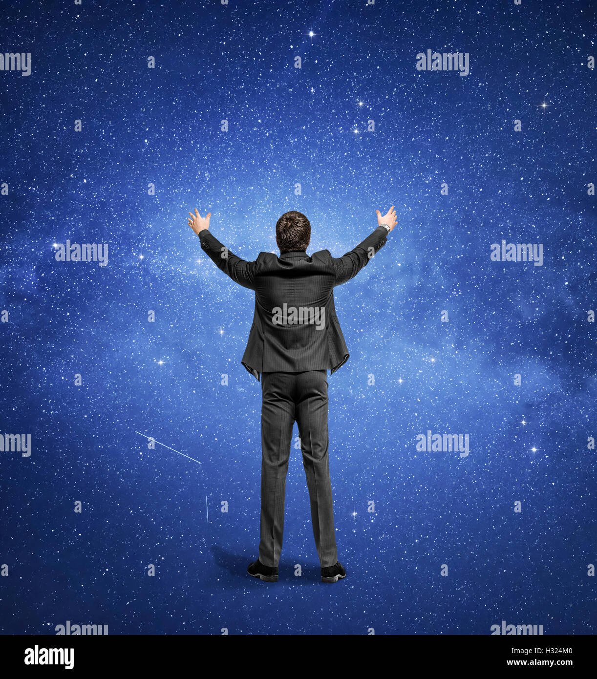 Man in a suit standing on the background of the night sky, the Milky ...