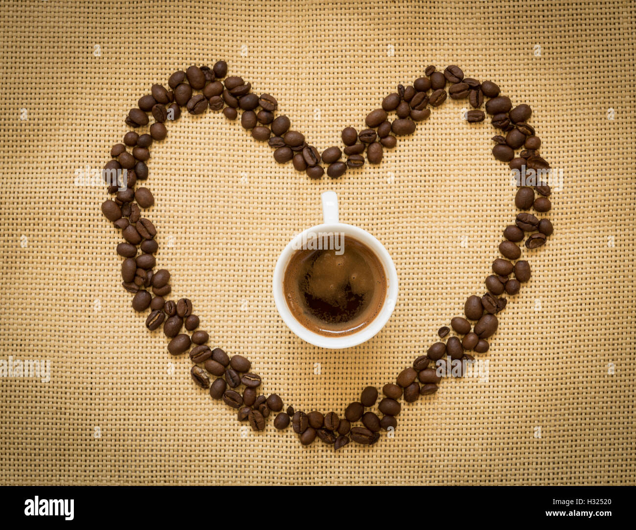 Coffee beans in the shape of heart symbol and a cup of black espresso ...