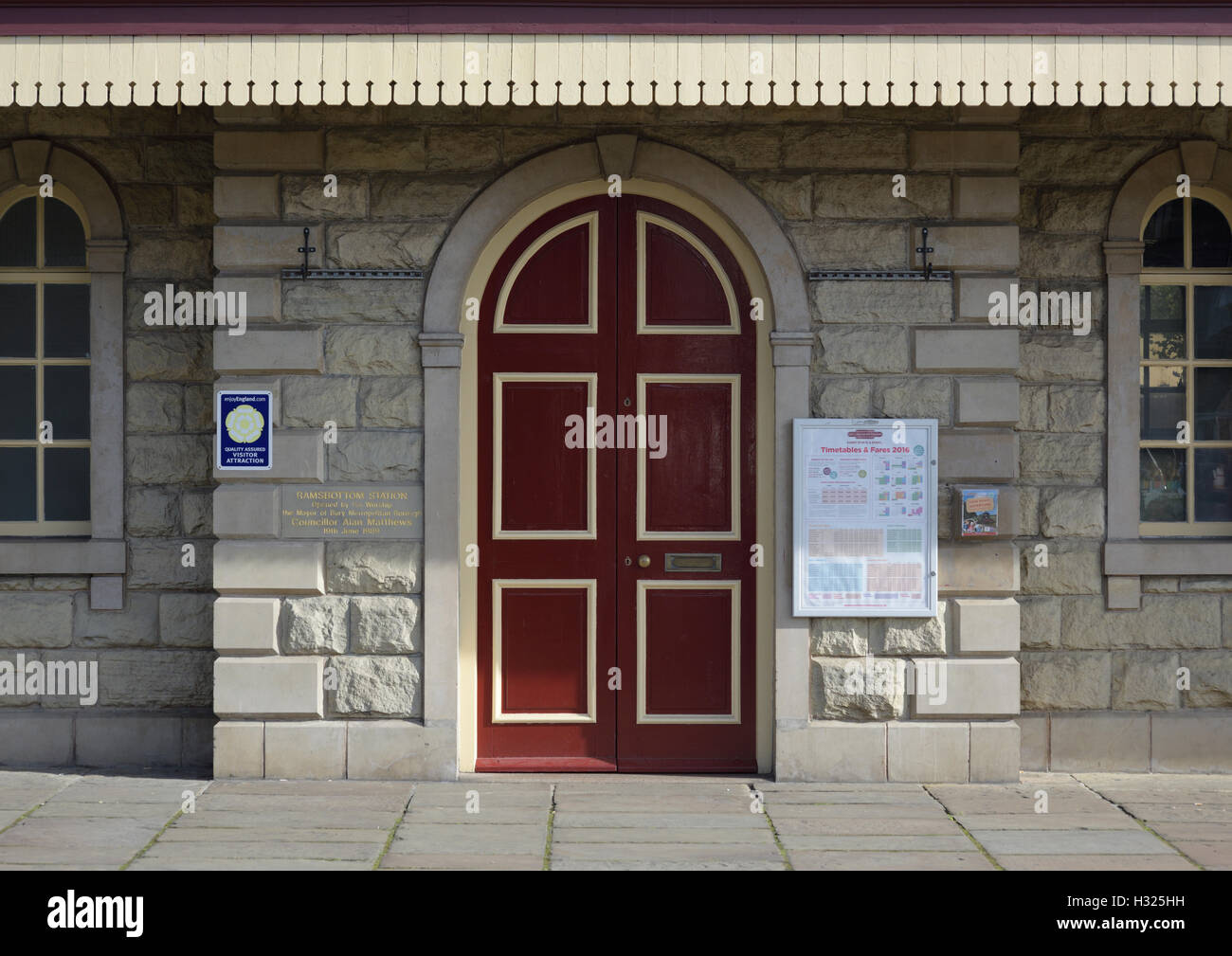Arched stone door surround with double doors and wooden roof valance on ...