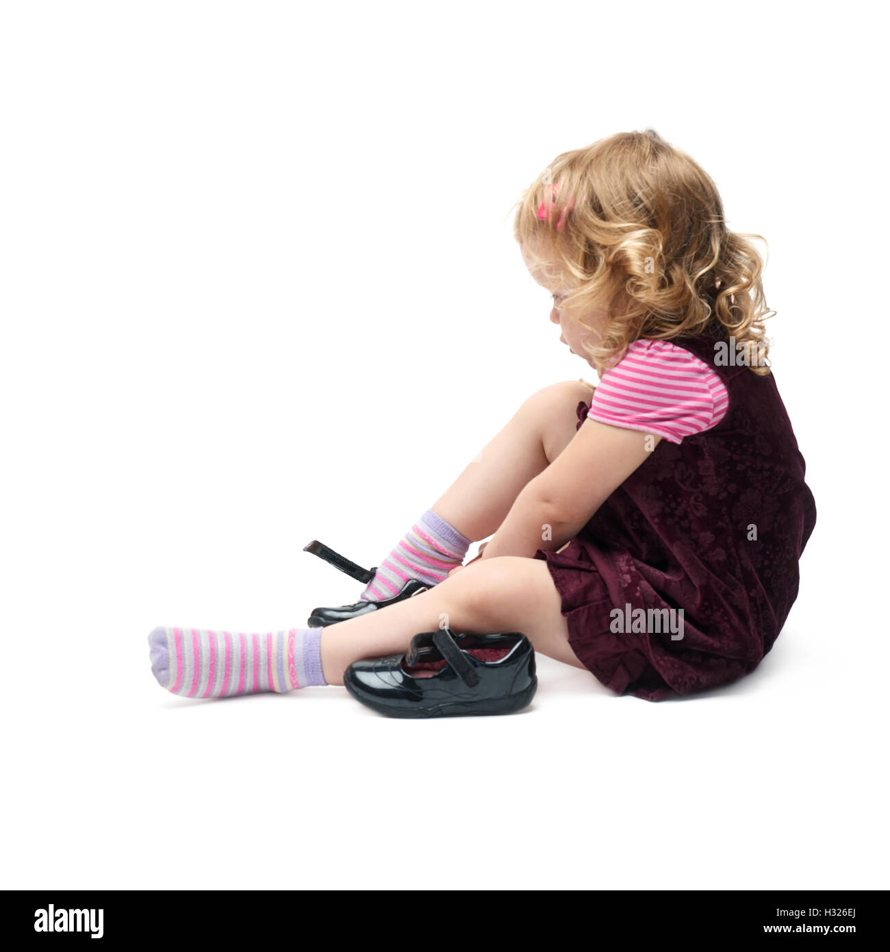 Young Little Girl Sitting Over Isolated White Background Stock Photo