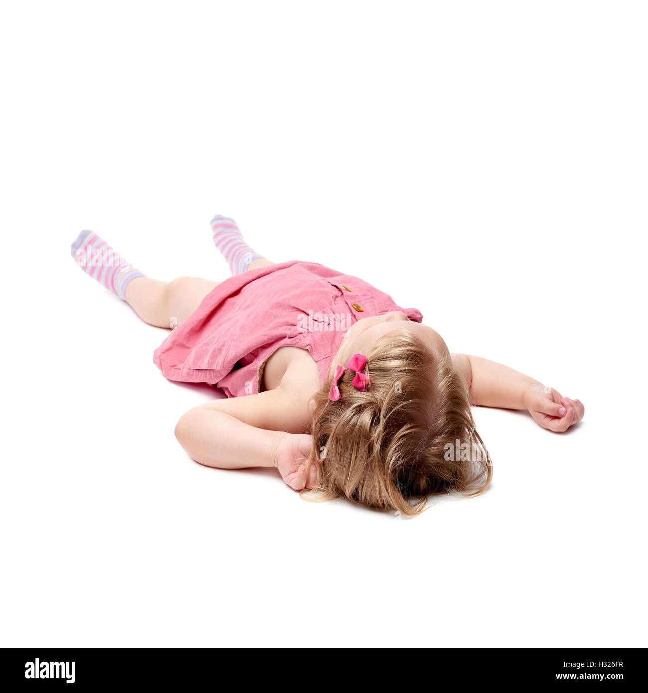Young little girl lying over isolated white background Stock Photo - Alamy