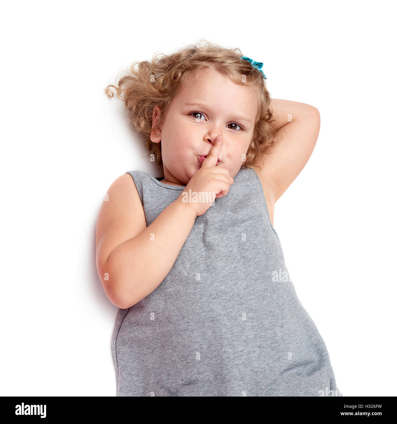 Young little girl lying over isolated white background Stock Photo - Alamy