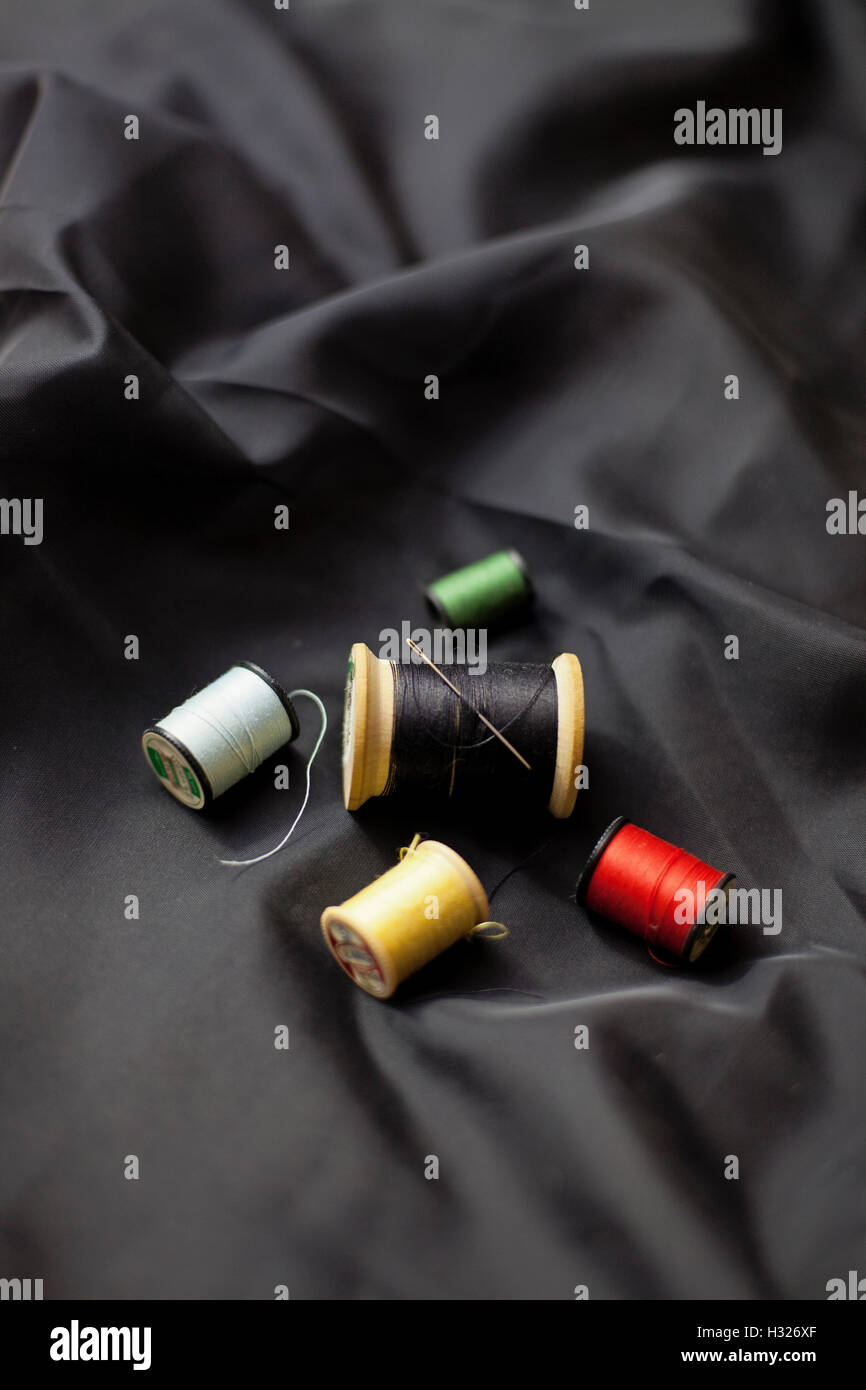 Spools of thread and a needle for sewing Stock Photo - Alamy