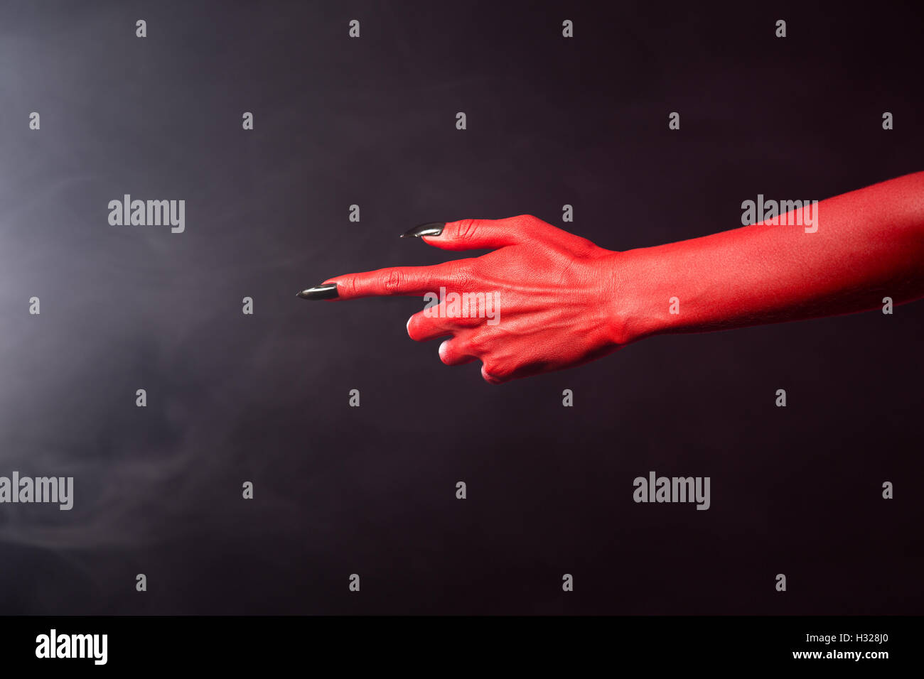 Red devil pointing hand with black sharp nails, extreme body-art Stock ...