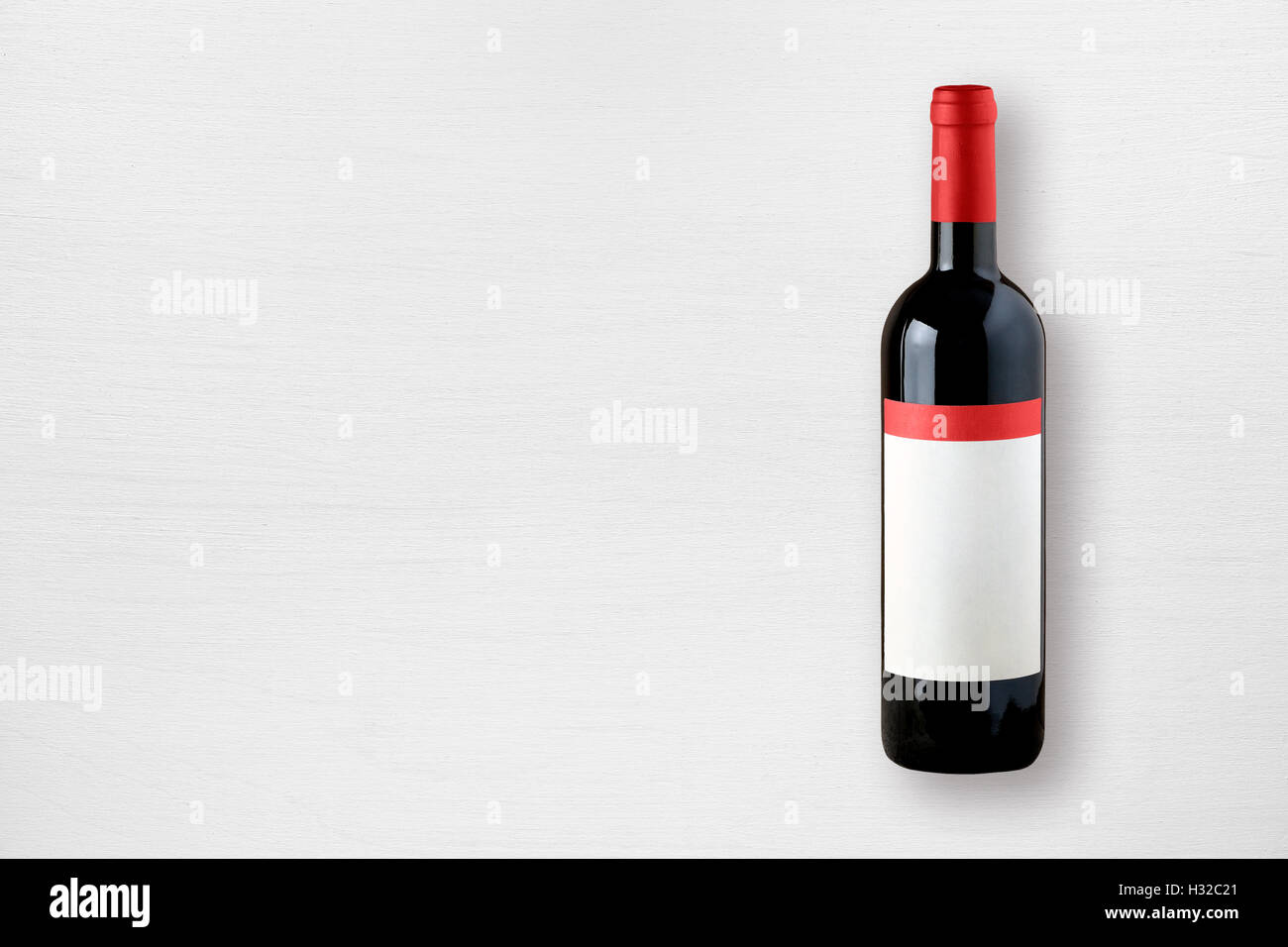 Red wine bottle on white table top view Stock Photo - Alamy
