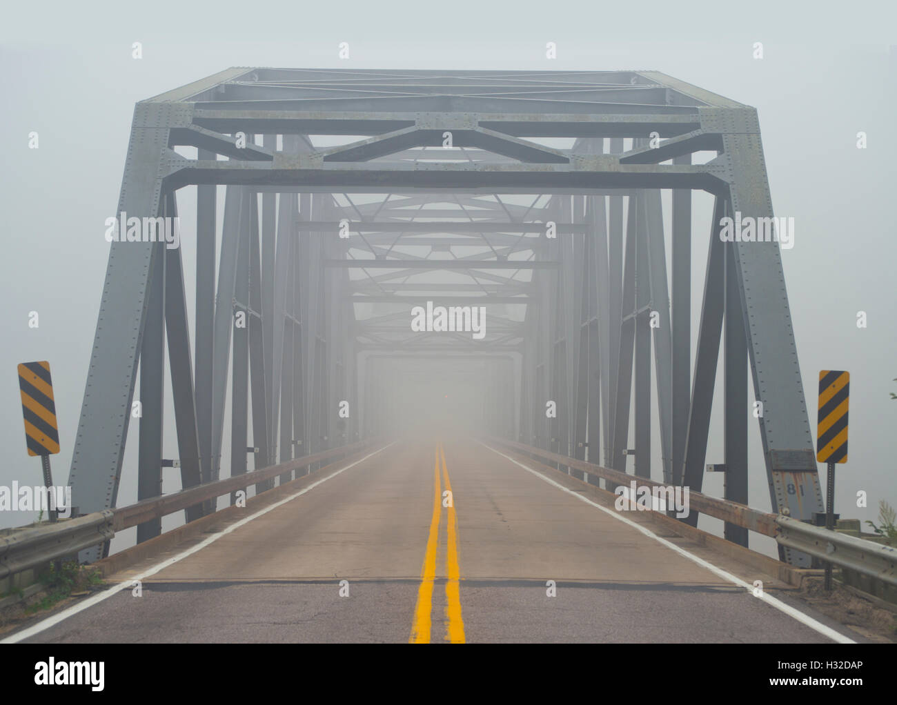 Photo looking down the road on a fog covered bridge Stock Photo - Alamy