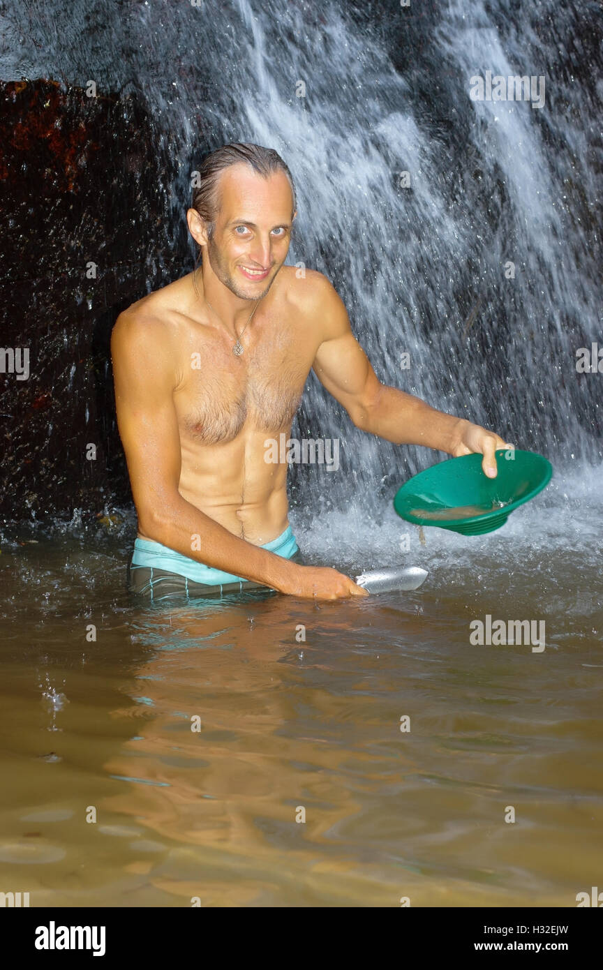 a man gold panning in a river with a sluice box Stock Photo - Alamy
