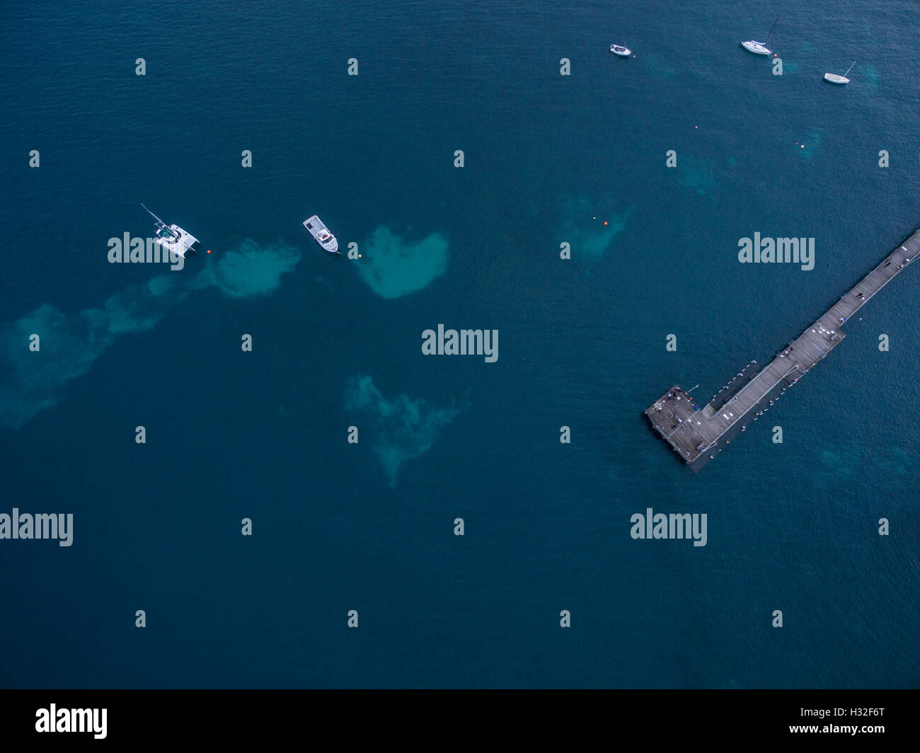Aerial view of Flinders pier with moored fishing boats at dusk ...