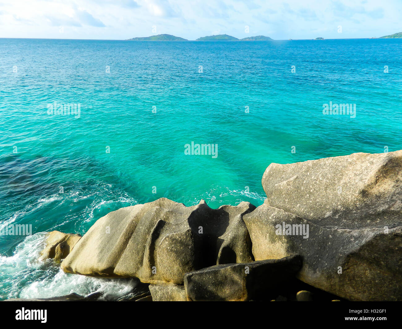 Daylight scene of the turquoise ocean and granit rocks and some little ...