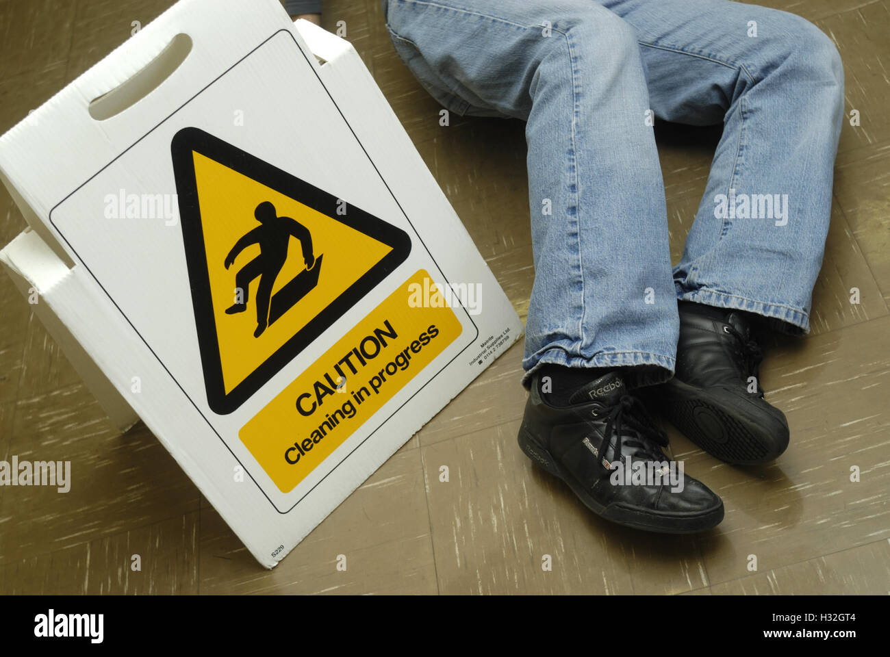 Man fallen next to caution sign Stock Photo - Alamy