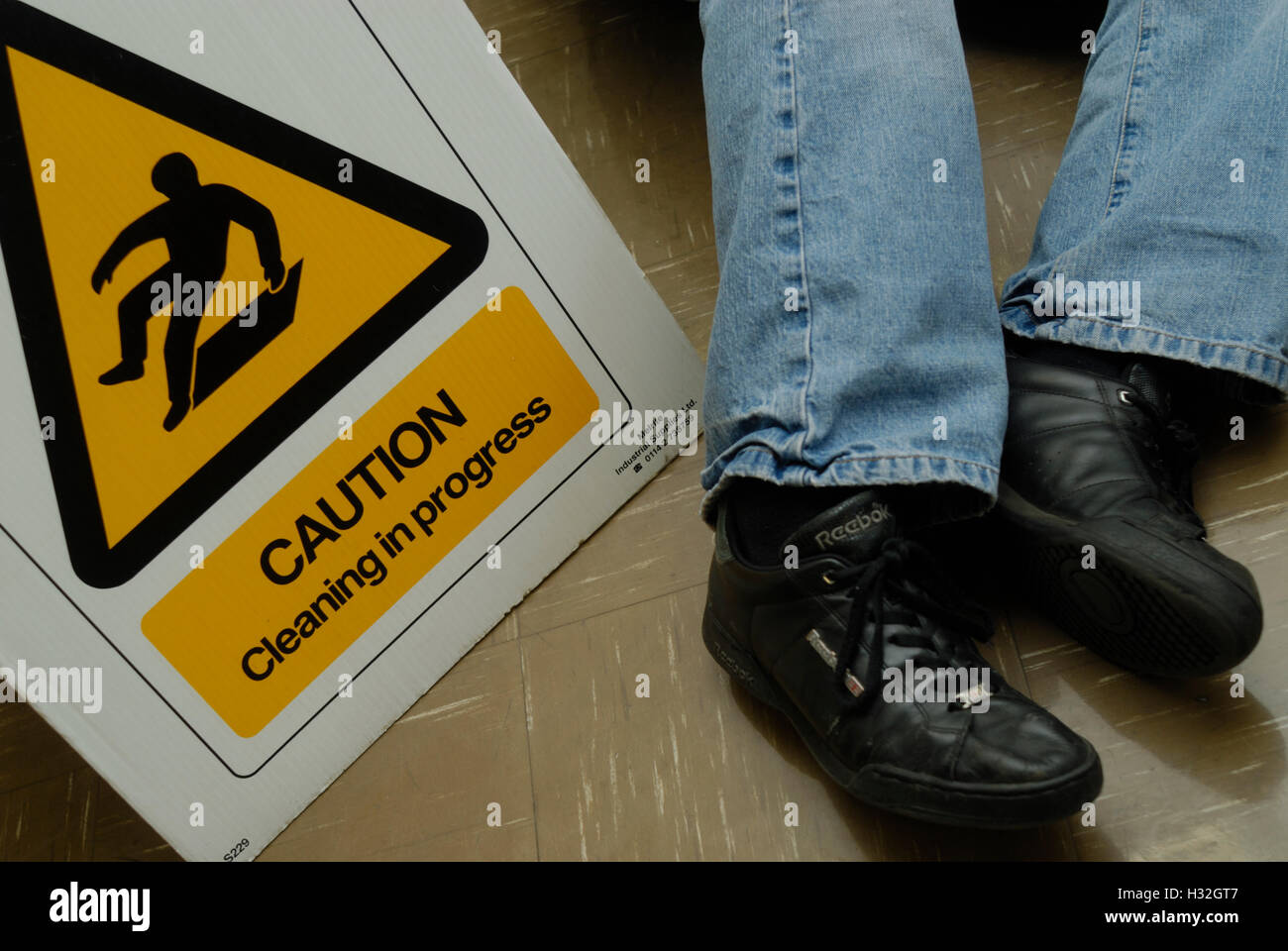 Man fallen next to caution sign Stock Photo - Alamy