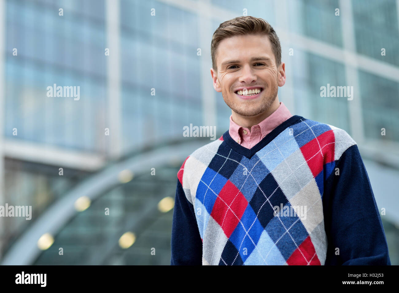 Young man standing outside modern building Stock Photo - Alamy