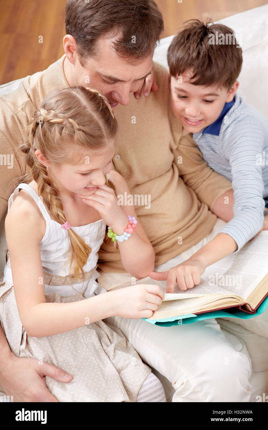 Reading book together Stock Photo - Alamy