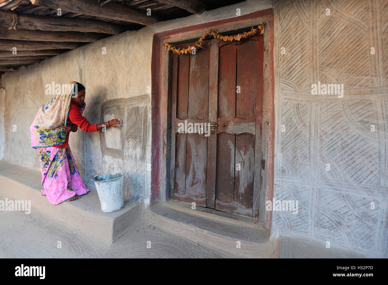 NAGESIA TRIBE, A Woman Painting a Chock Purna Design on house walls ...