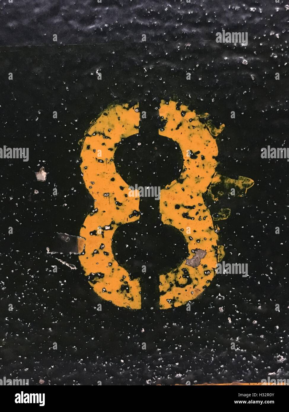 Number 8 painted in a stencil style in orange yellow color on the floor ...