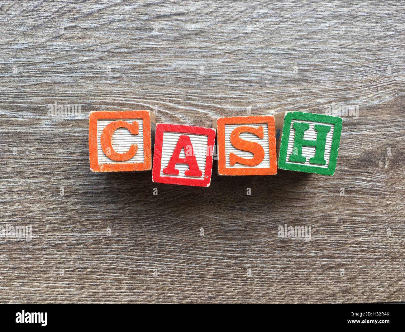 Alphabet wood block letters forming the word CASH, it is a way for ...