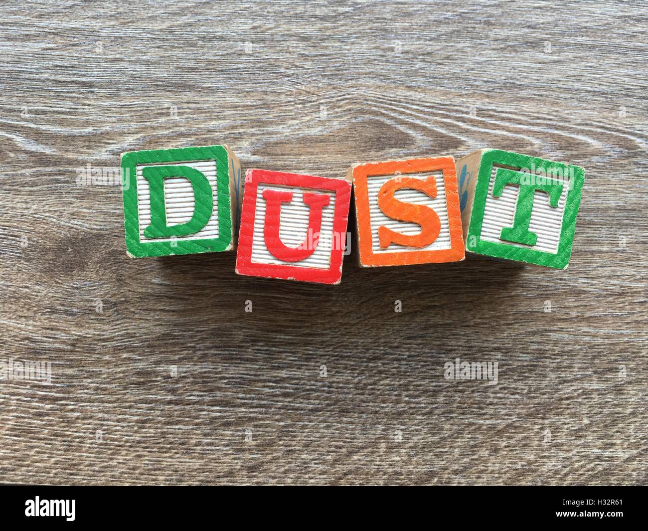 Alphabet wood block letters forming the word DUST, it is a way for ...