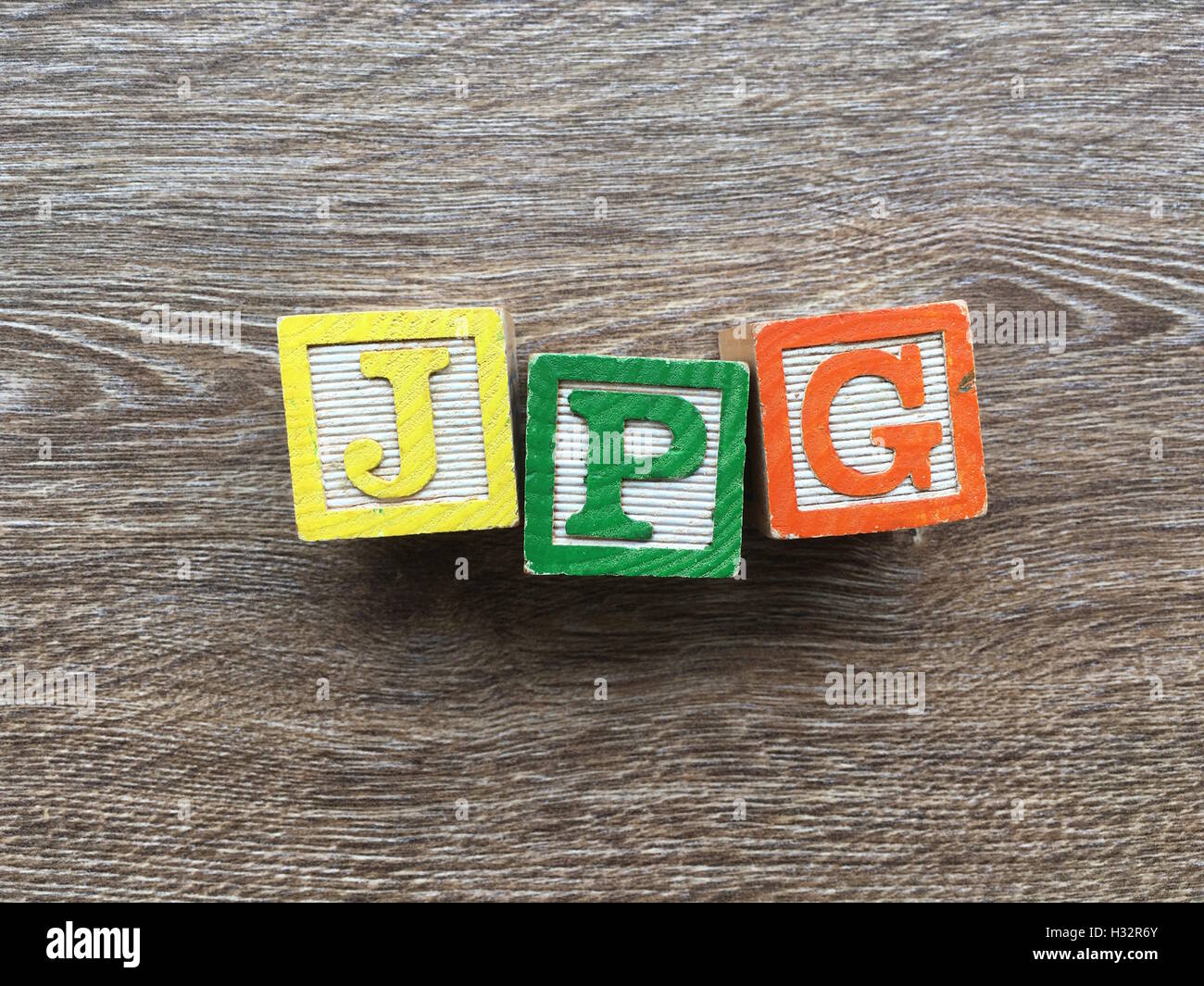 Alphabet wood block letters forming the word JPG for a digital picture ...