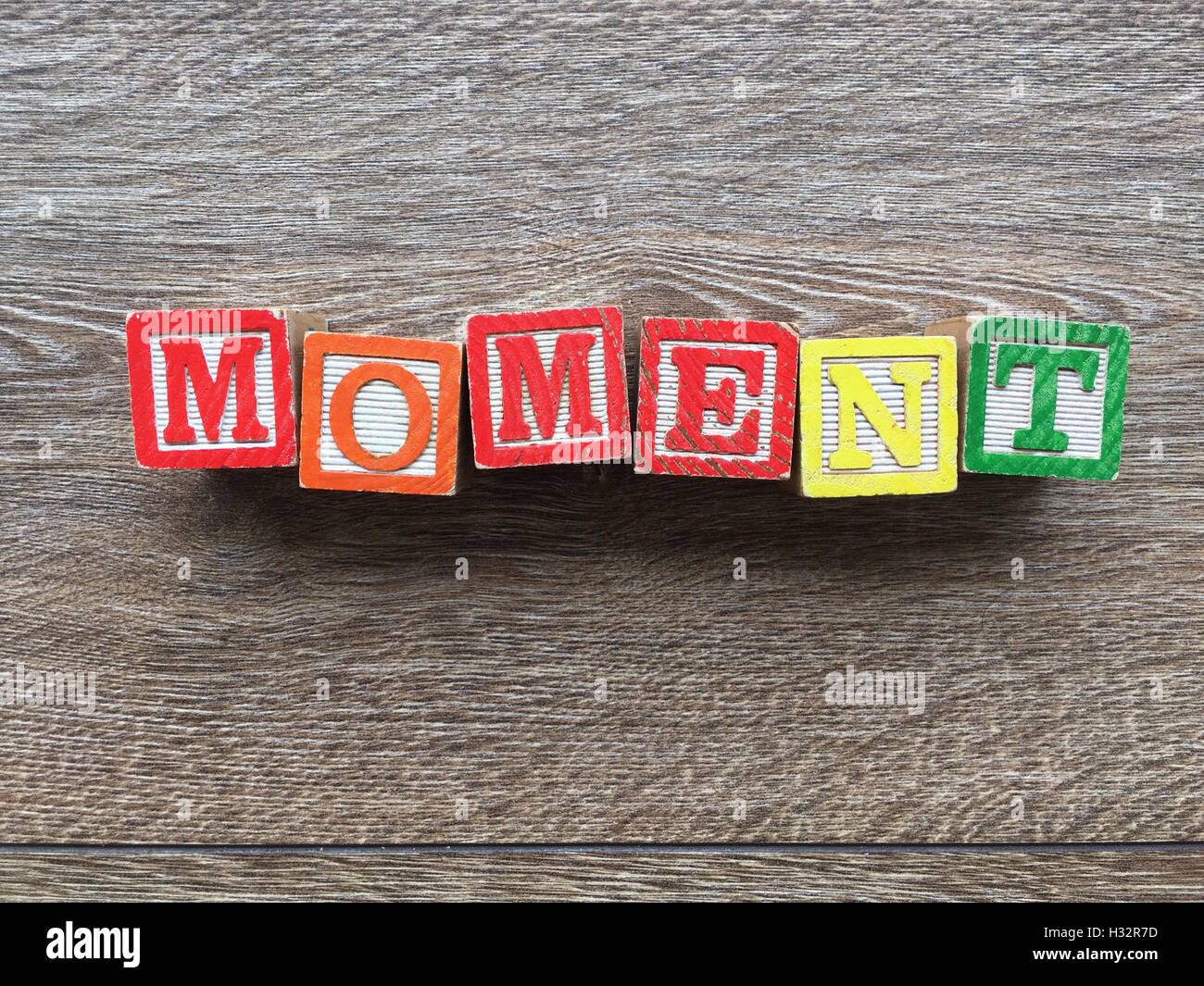 Alphabet wood block letters forming the word MOMENT. It's a typography ...
