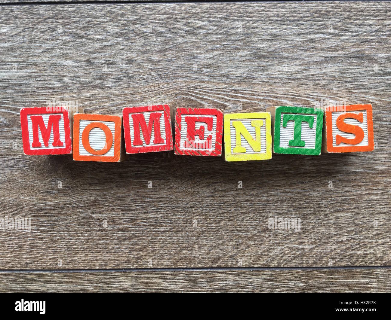 Alphabet wood block letters forming the word MOMENTS. It's a typography ...
