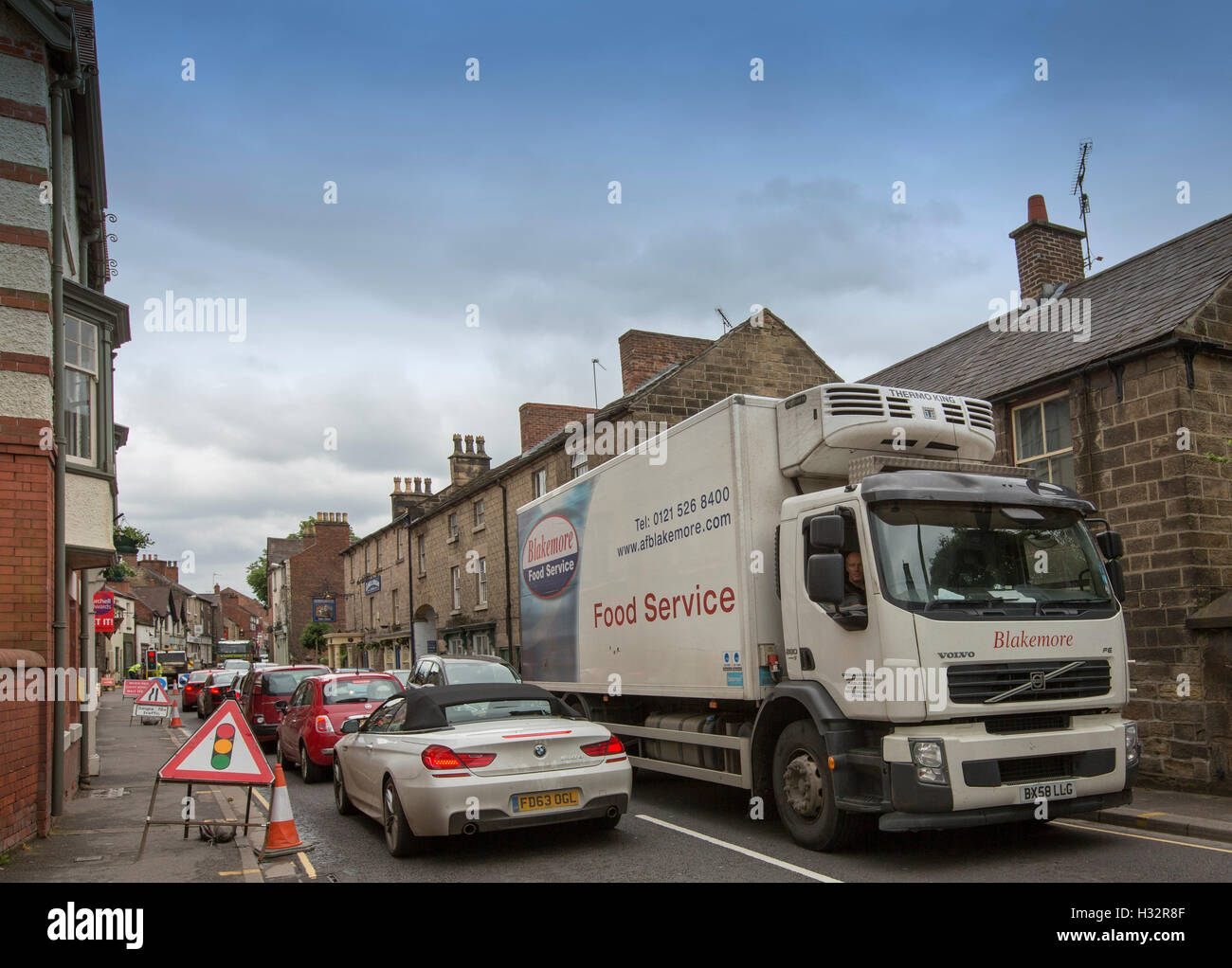 Roadworks in narrow street in English village of Belper with traffic ...