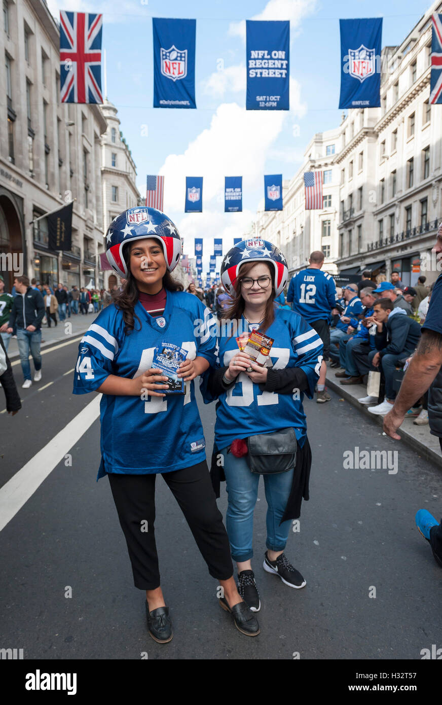 Two girls dressed up in NFL gear handing out leaflets to the public in ...