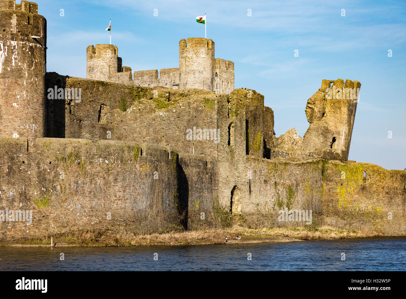 The moat and walls and leaning tower of Caerphilly Castle in the low ...