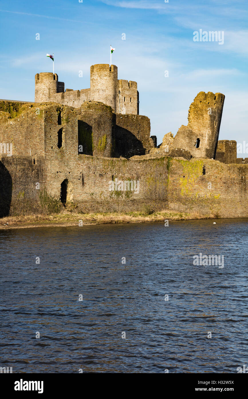 The moat and walls and leaning tower of Caerphilly Castle in the low ...