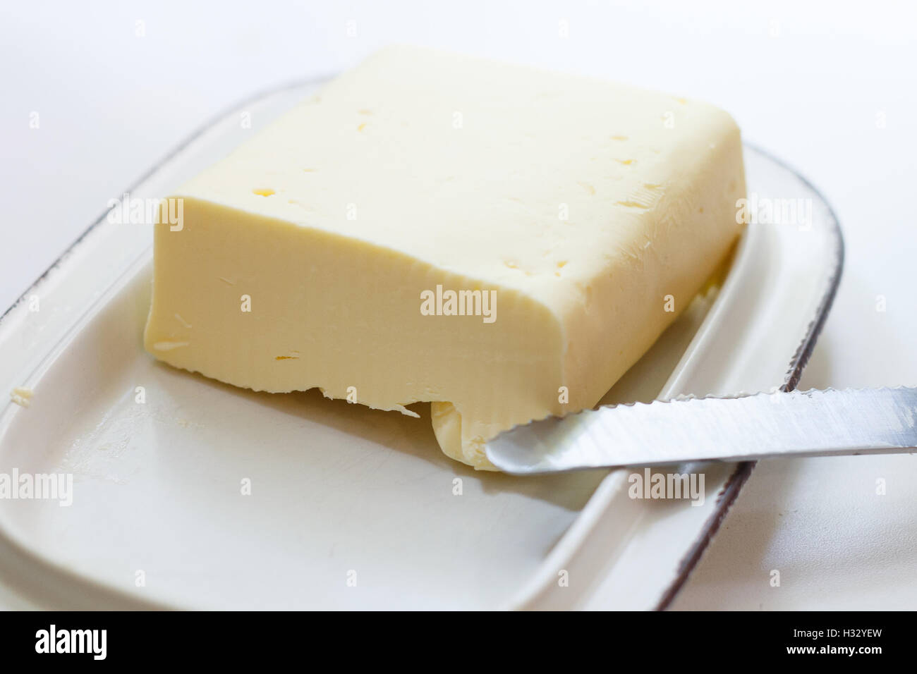 Pat of fresh farm butter on a butter dish with a knife Stock Photo - Alamy